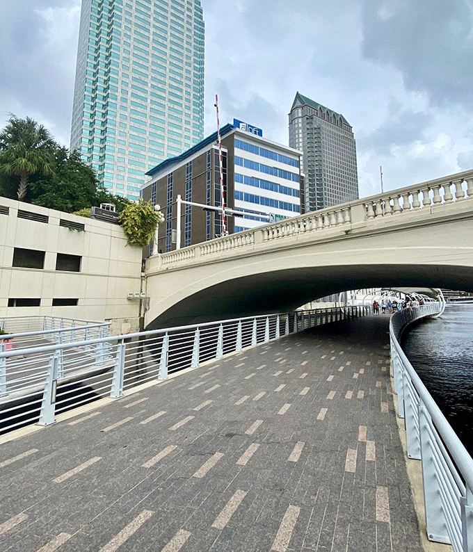 Walking under the bridge reveals one of the Riverwalk's many architectural features, where concrete and water create unexpected beauty.