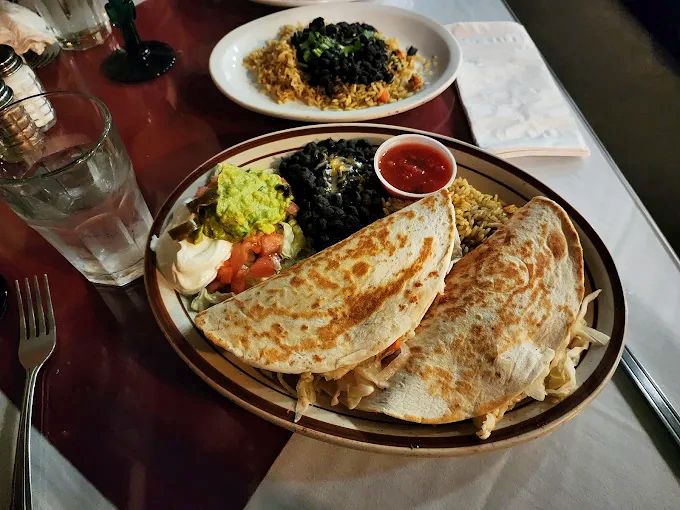 These quesadillas aren't messing around &ndash; stuffed to the edges and flanked by beans, rice, and all the fixings for a plate that requires strategy.