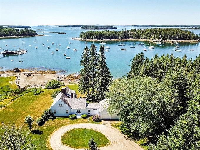 An aerial view of Brooklin reveals its perfect peninsula setting, with a white farmhouse standing sentinel over blue waters dotted with islands and boats. 