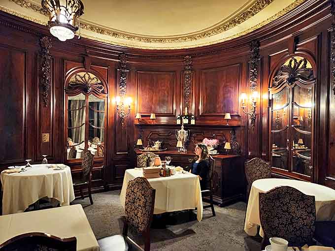 Rich wood paneling and ornate details create a dining room that feels like stepping into a gilded age mansion.