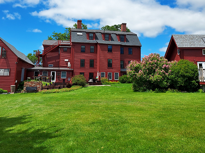 The vibrant red buildings of Deer Isle stand out against the coastal landscape, their bold color a beacon for boats returning to this working harbor.