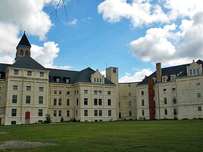Empty buildings stand in silent formation, the Fergus Falls complex's white walls and red roofs creating a haunting institutional skyline.