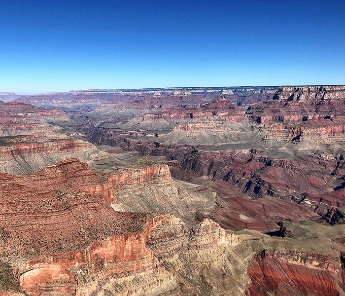 Sunset paints the Grand Canyon in golden light, highlighting the immense depth and scale of America's most famous natural wonder.