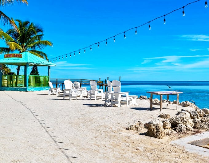 Paradise found: Where turquoise waters meet cloudless skies, white Adirondack chairs invite you to slow down and breathe deeply.