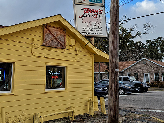 The sunshine-yellow exterior of Terry's Drive-In stands as a beacon of burger bliss, proudly displaying its porcine mascot since 1939.