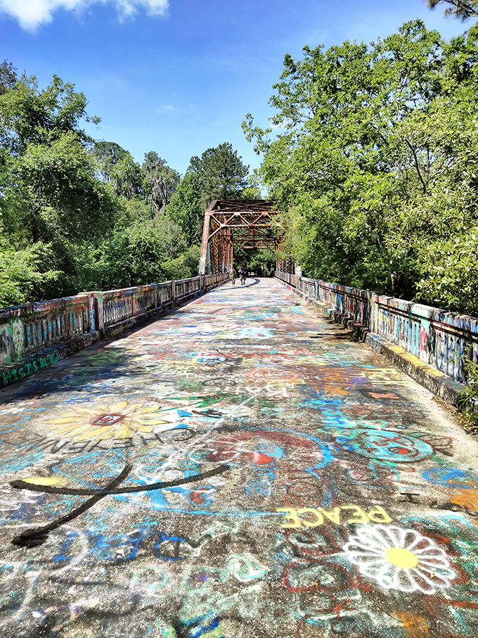 The Suwannee Springs Bridge stretches like a colorful ribbon across the river, each footstep revealing new artistic expressions from visitors past.