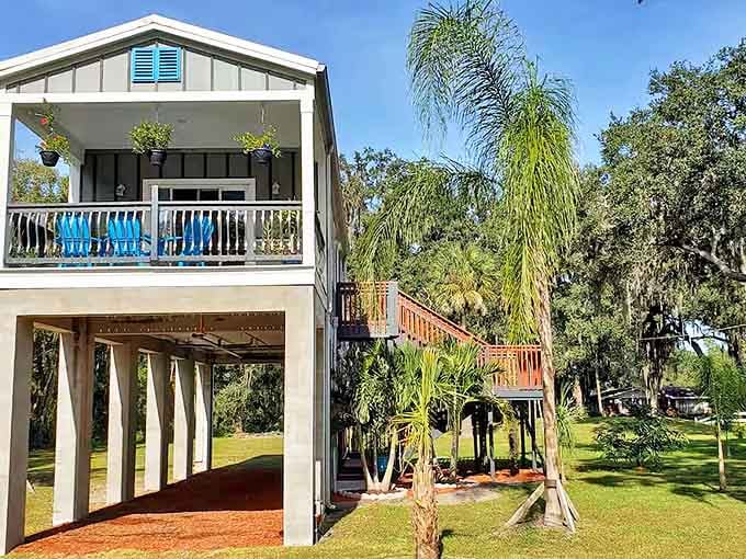 The Strawberry Field Stilt House stands proudly elevated, a white beacon above crimson fields where childhood dreams meet grown-up comforts.