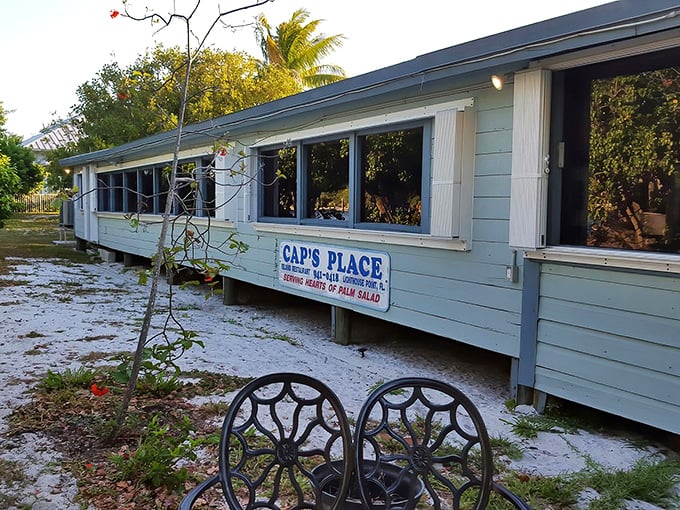 The weathered blue exterior of Cap's Place stands as a defiant reminder that Florida's most authentic treasures don't come with neon signs or valet parking.