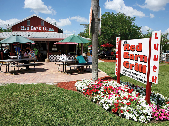 The iconic red barn stands out against Florida's blue sky like a culinary lighthouse, beckoning hungry travelers with promises of comfort food paradise.