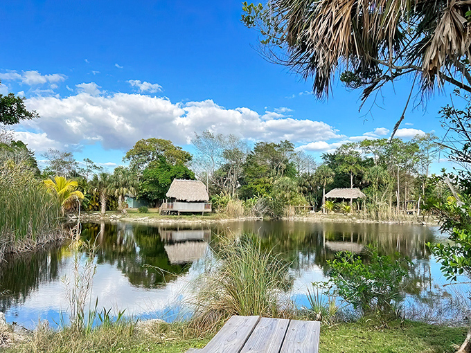 Tranquility meets mystery at Trail Lakes Campground, where thatched-roof chickees reflect perfectly in still waters that might hide secrets.