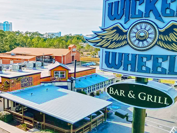 The iconic Wicked Wheel sign blazes against the Florida sky, its flaming winged wheel design promising both automotive flair and culinary adventure.