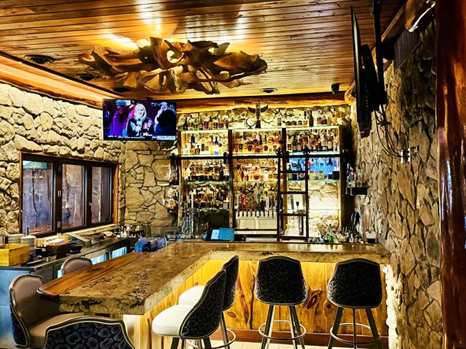 The stone-walled bar area feels like a sophisticated grotto, with amber-lit shelves displaying an impressive collection of spirits for crafting their signature cocktails.