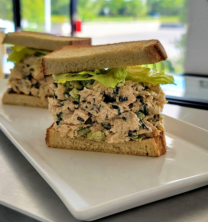 A perfectly proportioned chicken salad sandwich on toasted bread &ndash; simple food done right, with no unnecessary frills.