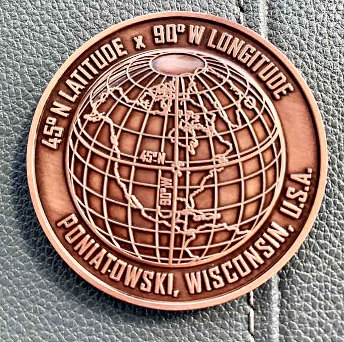 The detailed commemorative coin serves as a tangible memory of standing at one of Earth's most precisely located points.