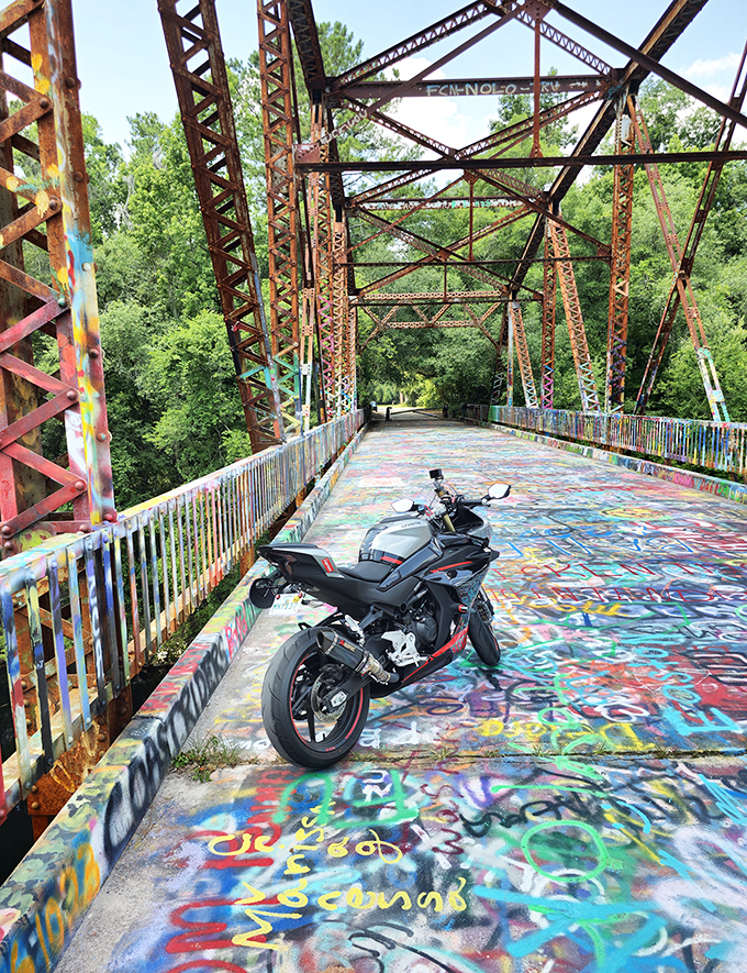 A motorcycle rests on the bridge's kaleidoscopic surface, the perfect pit stop for riders seeking roads less traveled.