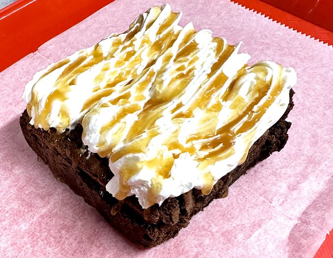 A brownie that's dressed for success with whipped cream and caramel drizzle &ndash; because sometimes chocolate needs accessories too.