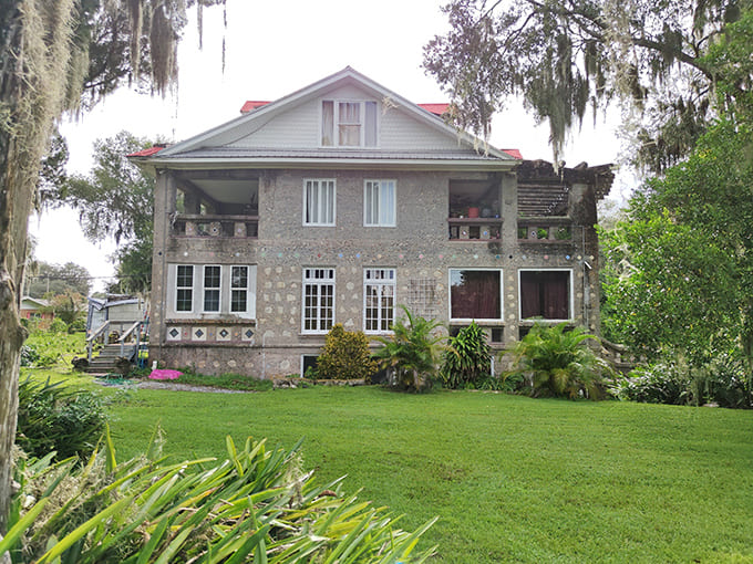 Red-stained concrete and vine-covered pergolas create outdoor spaces that blur the line between architecture and nature, and nobody seems to mind the confusion.