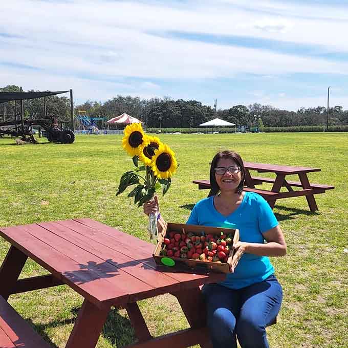 A visitor shows off the fruits of her labor, literally, with fresh-picked strawberries and sunflowers that didn't cost a fortune at some fancy market.