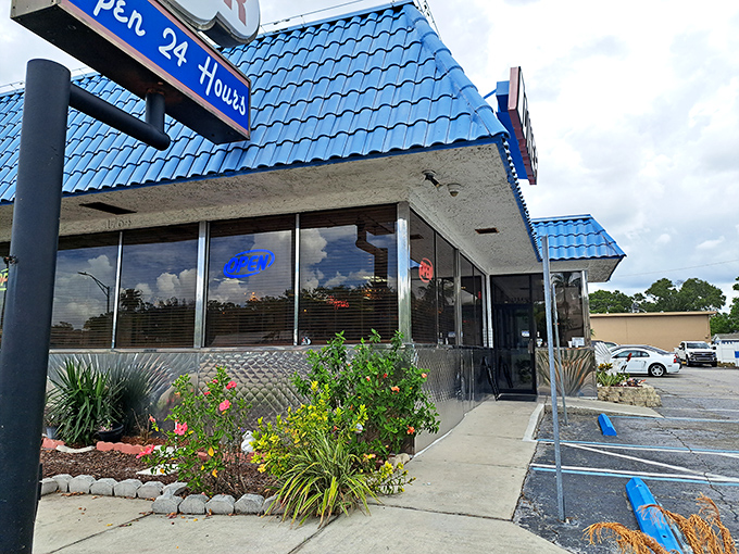 The welcoming entrance to Papa's, where tropical plants add Florida flair to the classic diner aesthetic that promises comfort inside.