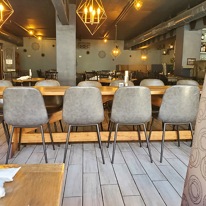 Modern gray chairs line communal tables where strangers become friends over shared plates and the universal language of good food.