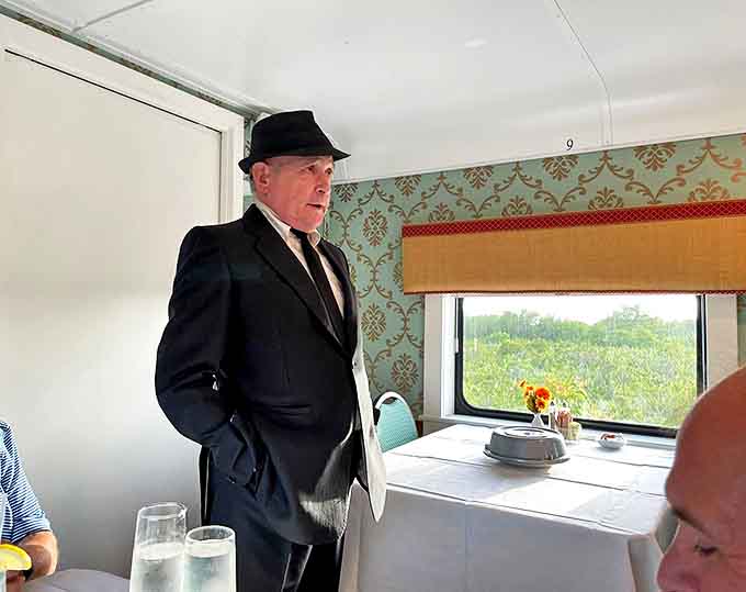 The conductor maintains his character throughout the journey, his serious demeanor adding authenticity to this rolling theater experience.