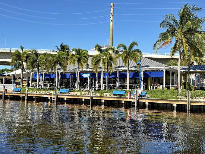 Blue umbrellas shade outdoor diners at Sailor's Return, where watching boats come and go adds to the waterfront dining experience.