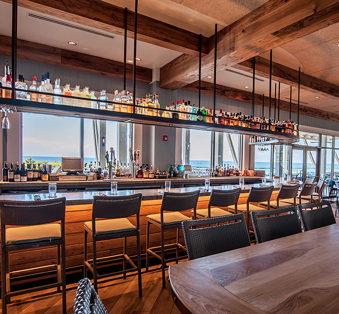 The bar doesn't just serve drinks &ndash; it frames the ocean view like it's a living painting. Those spirits are arranged with gallery-worthy precision.