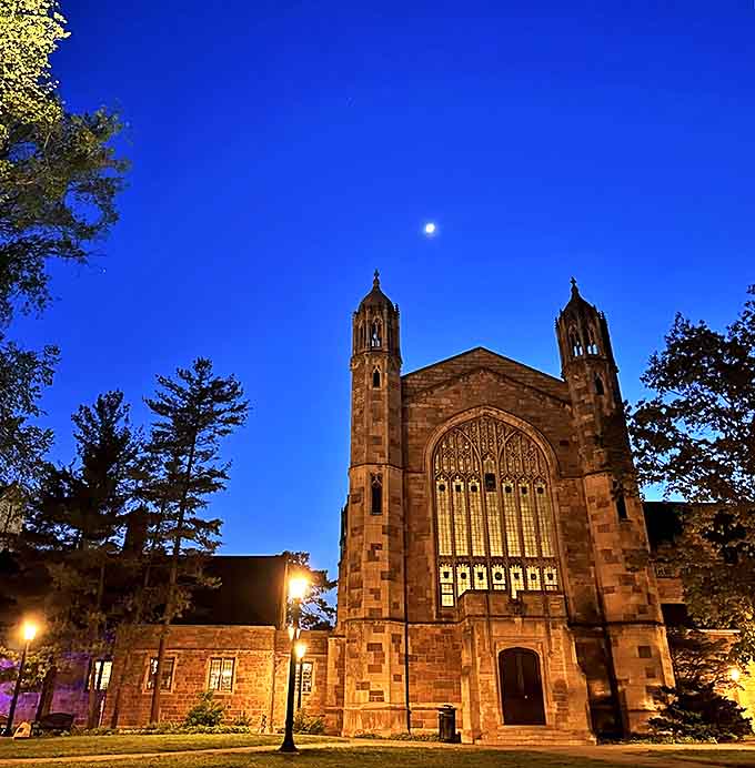 As night falls, the Law Library's illuminated windows transform the building into a lantern of knowledge, glowing against the velvet Michigan sky.