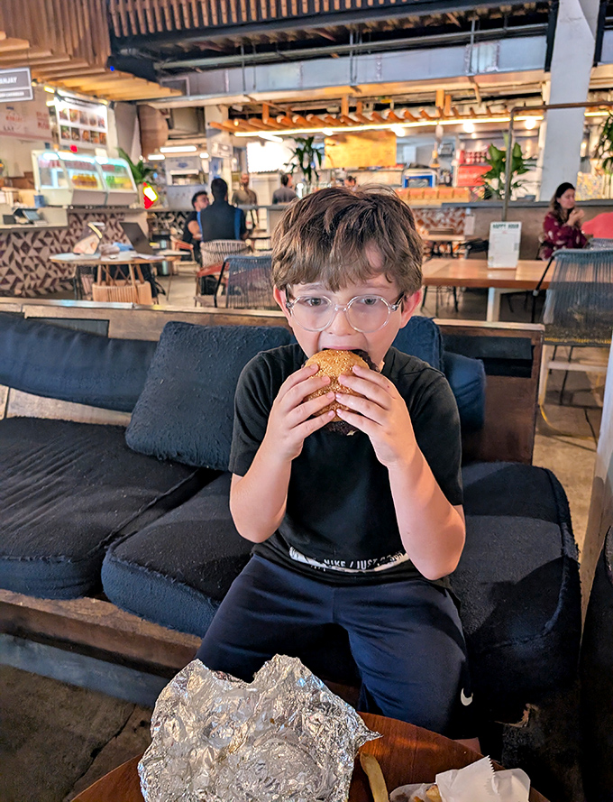 A young diner enjoys his USBS creation in the modern, comfortable dining area &ndash; proof that good taste starts early.