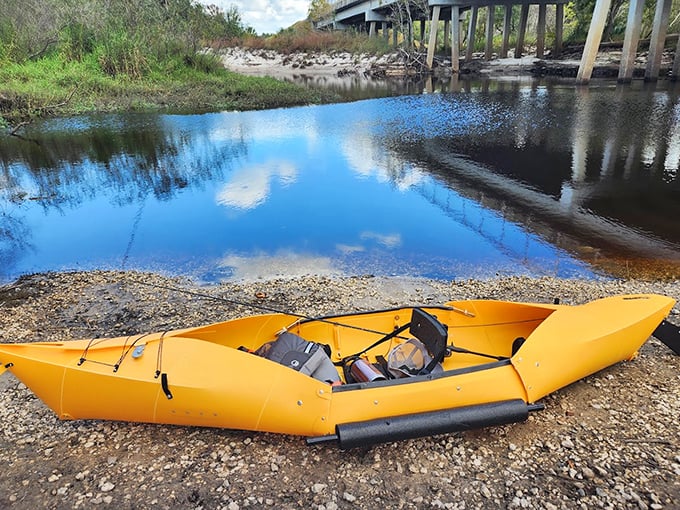 A bright yellow kayak waits patiently on shore, ready to transform spectators into participants in the river's flowing story.