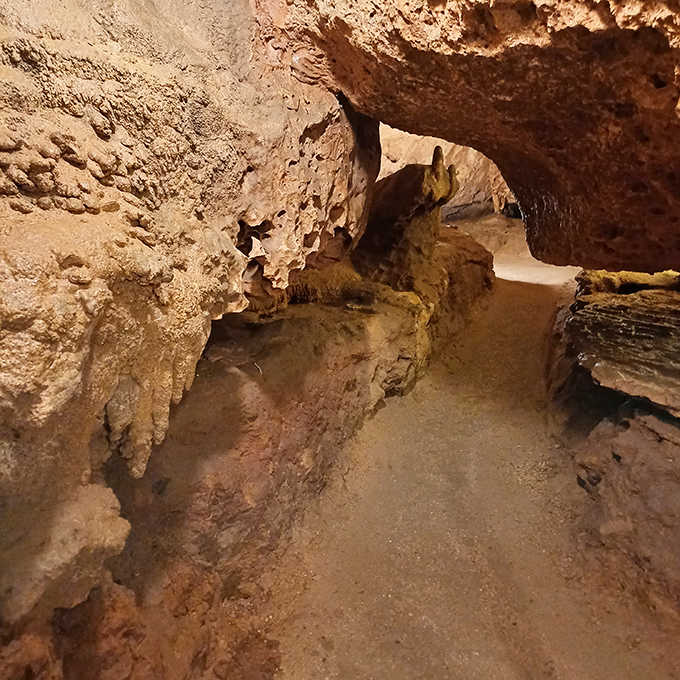 The carefully maintained pathway winds through narrow passages, revealing chambers that feel like nature's own cathedral.