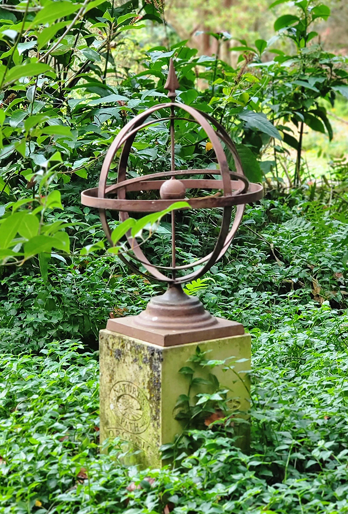 An armillary sphere stands like a scientific wizard's tool, measuring sunlight and casting geometric shadows across the garden floor.