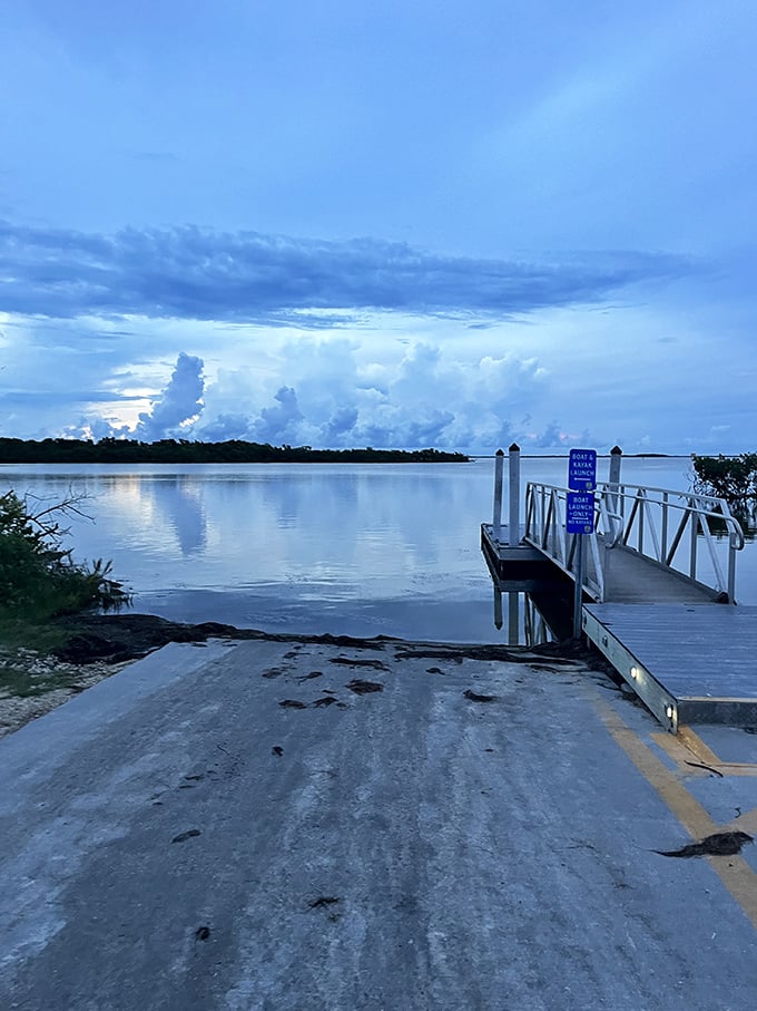 The boat launch transforms into a gateway to adventure as storm clouds gather dramatically in the distance.