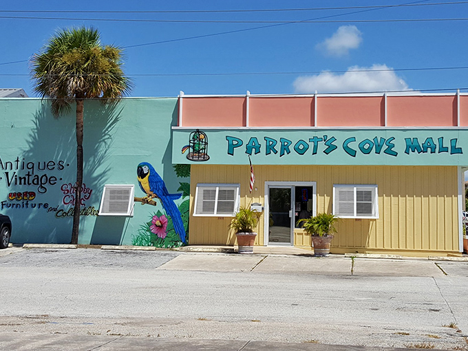 Parrot's Cove Mall brings tropical vibrancy to shopping with its cheerful facade and whimsical blue macaw mural guarding the entrance.