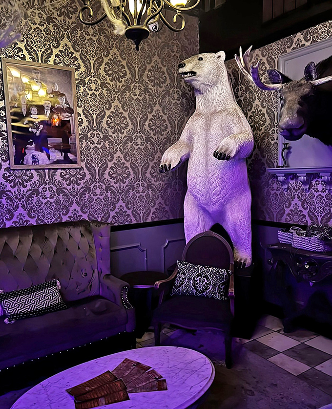 This life-sized polar bear statue creates a striking focal point against the ornate damask wallpaper, surprising visitors with unexpected taxidermy.