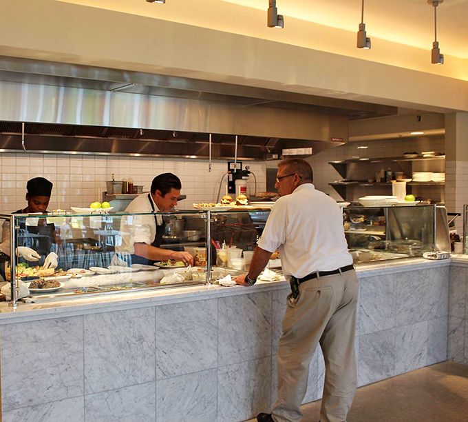 The open kitchen reveals culinary artisans at work, crafting garden-inspired dishes with the precision of botanical scientists and the soul of artists.