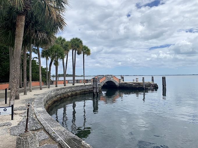 The stone seawall curves gracefully along Biscayne Bay, where even the fish probably feel underdressed for such elegant surroundings.
