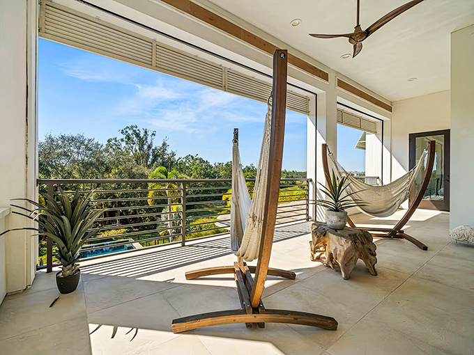 Suspended bliss awaits on this balcony where hammocks sway gently between wooden posts with views of the tropical landscape below.