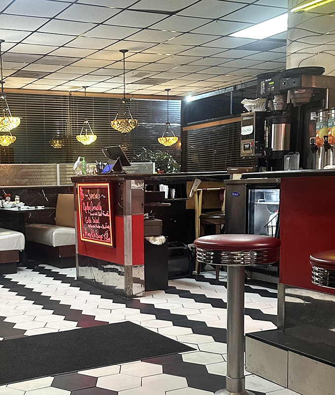 The black and white hexagonal floor tiles create a classic foundation for the diner's interior, complemented by comfortable booth seating.
