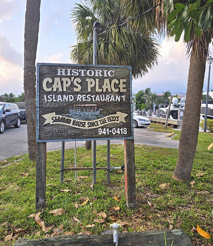 Signage: "Historic Cap's Place" announces the weathered sign, standing guard among palm trees like a sentinel protecting Florida's delicious past from modern intrusion.