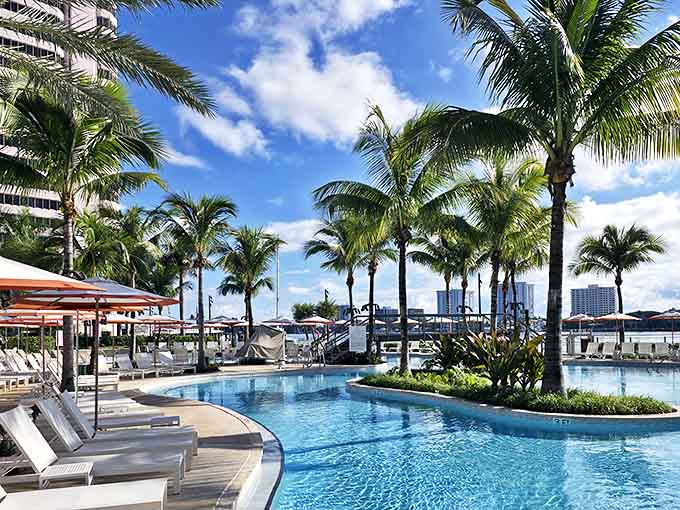 The umbrellas pop against the turquoise pool at The Boca Raton, where cabanas and loungers invite romantic relaxation.