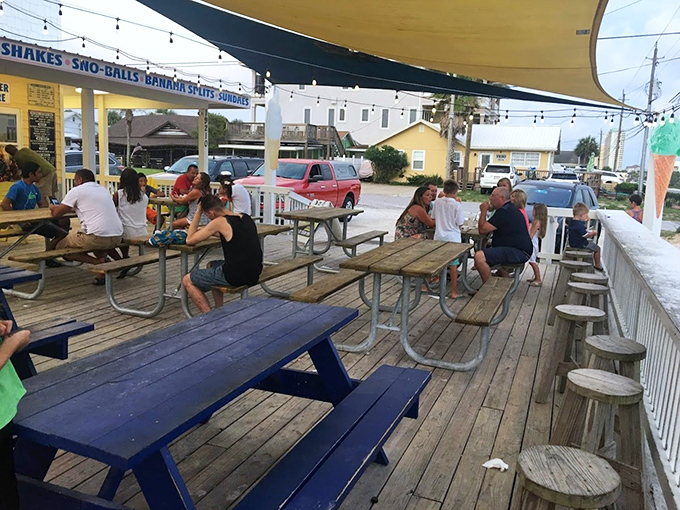 Wooden picnic tables under string lights &ndash; the perfect setting for savoring treats while catching Gulf breezes.