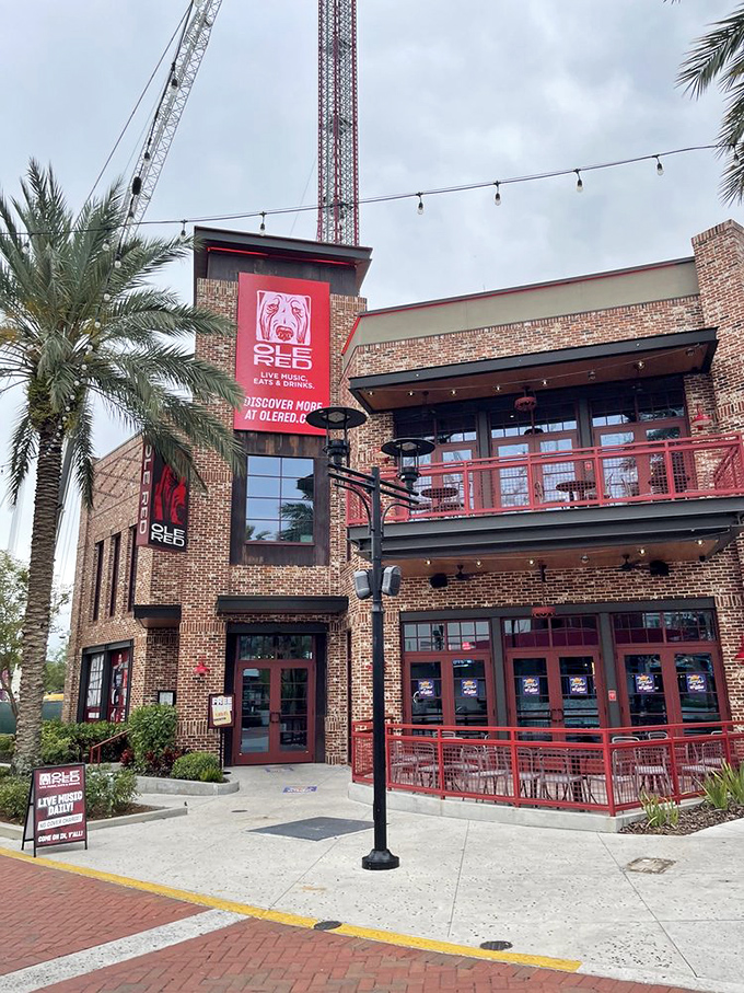 Palm trees frame the brick exterior as dusk settles &ndash; Ole Red's welcoming facade promises good times before you even step inside.