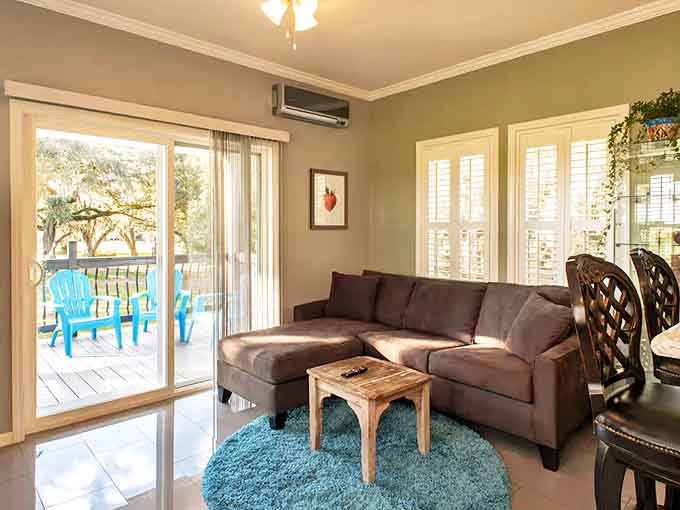 The living room's earth-toned sectional and turquoise accents mirror the natural palette outside, bringing the outdoors in through design.