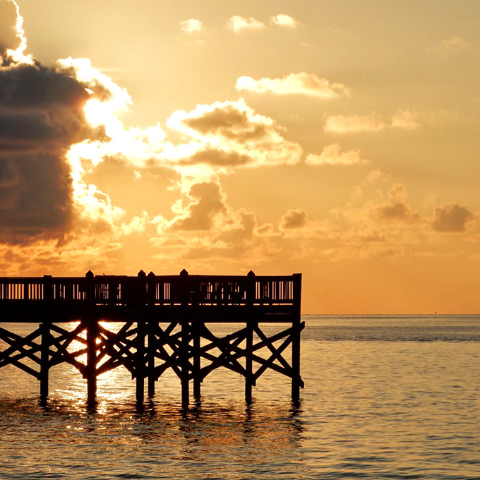 Silhouetted against a fiery sky, the fishing pier stands as silent witness to another day's perfect ending in paradise.