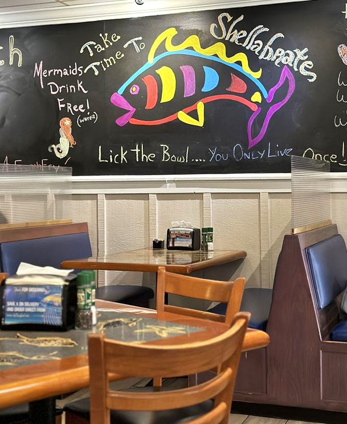 Whimsical chalkboard art declares "Mermaids Drink Free!" &ndash; the playful spirit of Shells captured in colorful chalk and good-natured humor.