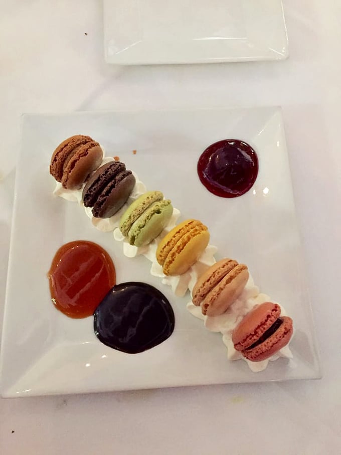 A rainbow of macarons lined up like well-behaved swimmers at the edge of a pool—ready to dive straight into your heart.
