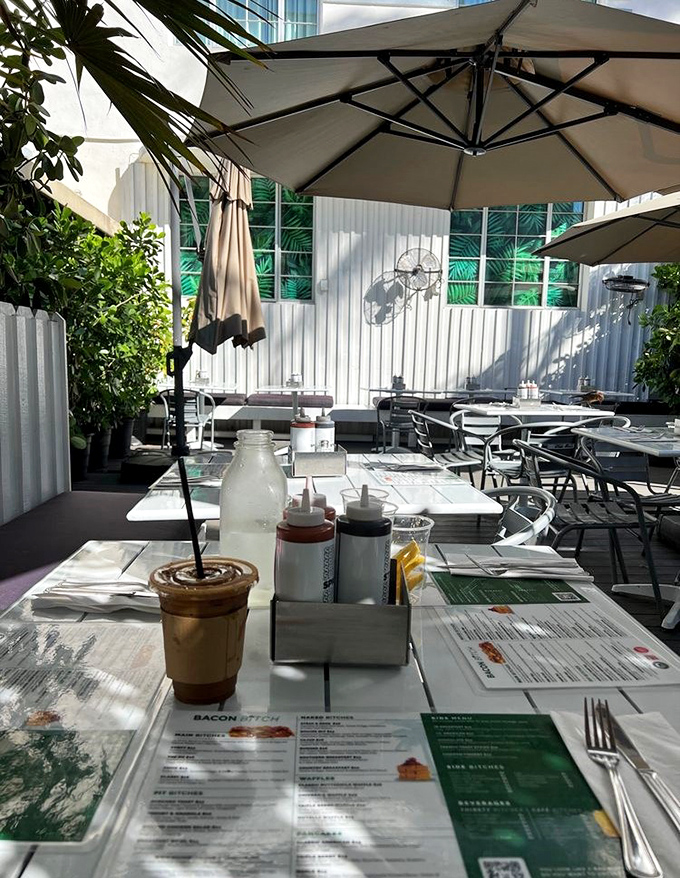 Sun-dappled outdoor tables set with all the essentials &ndash; menus, condiments, and plenty of space for the bacon feast to come.