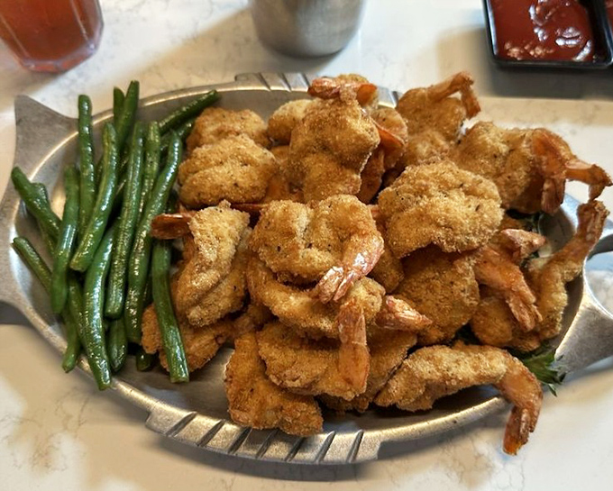 A mountain of golden fried shrimp shares the plate with fresh green beans &ndash; proof that sometimes the classics, when executed perfectly, are all you need.