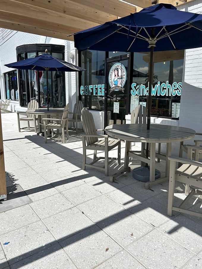 Navy umbrellas shade comfortable seating outside the caf&eacute;, offering a perfect spot for people-watching while enjoying treats.